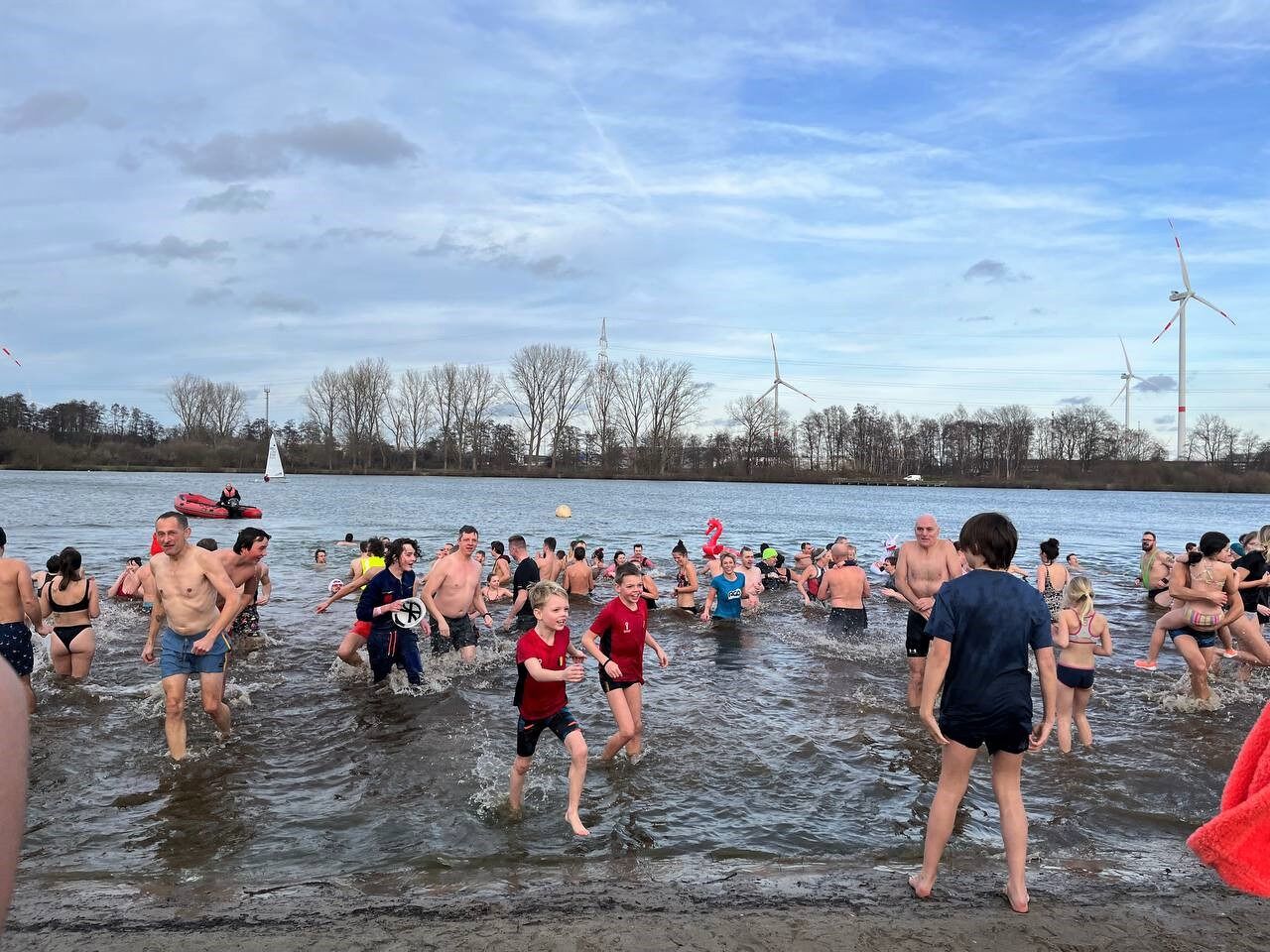 Enthousiaste zwemmers duiken in het koude water van de Paalse Plas in ...